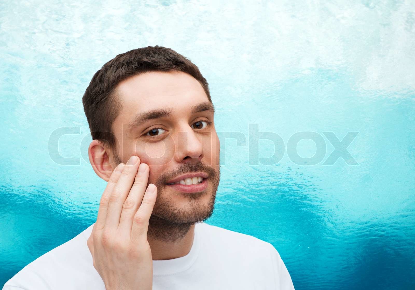 beautiful smiling man touching his face | Stock image | Colourbox