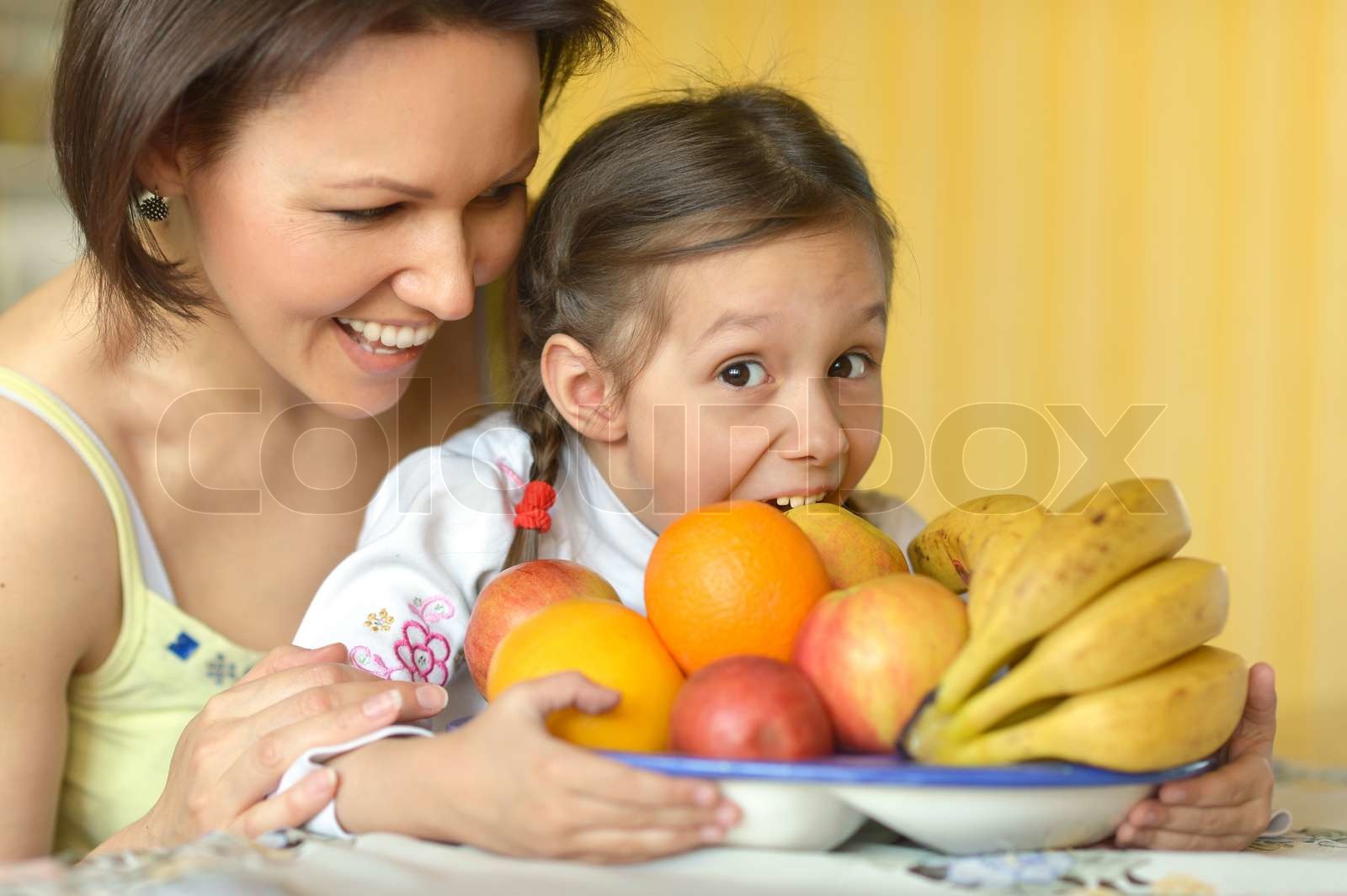 Mother and daughter eating fruits | Stock image | Colourbox