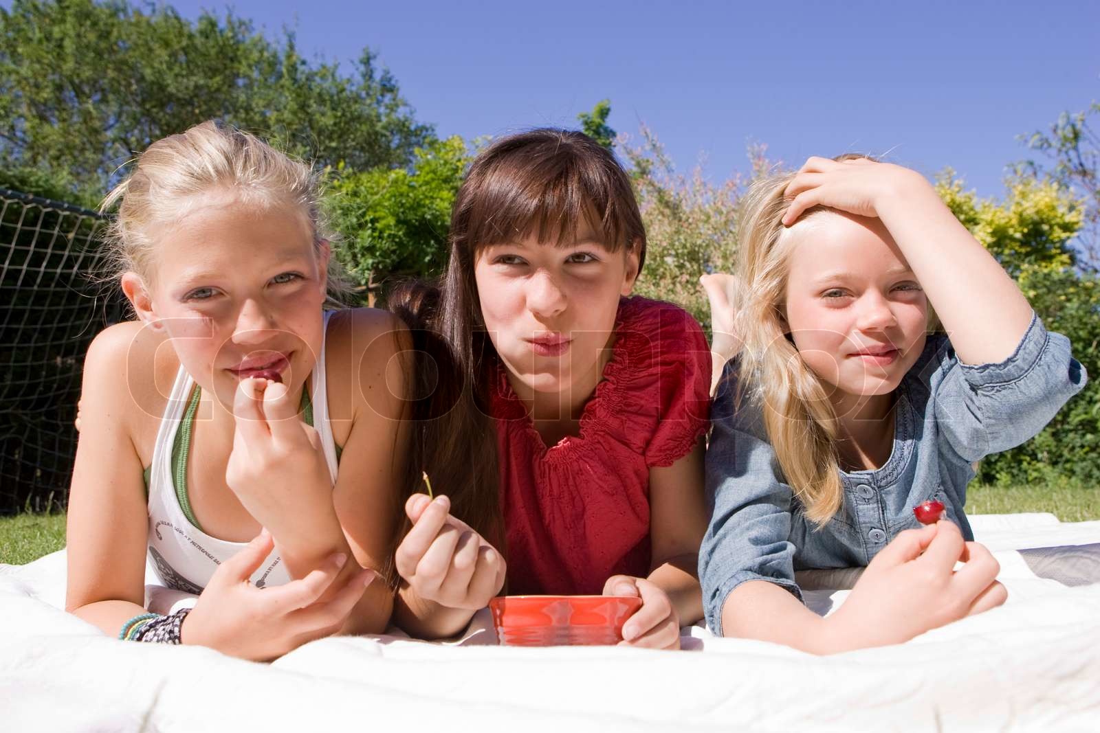 Three teenage girls eating cherries | Stock image | Colourbox