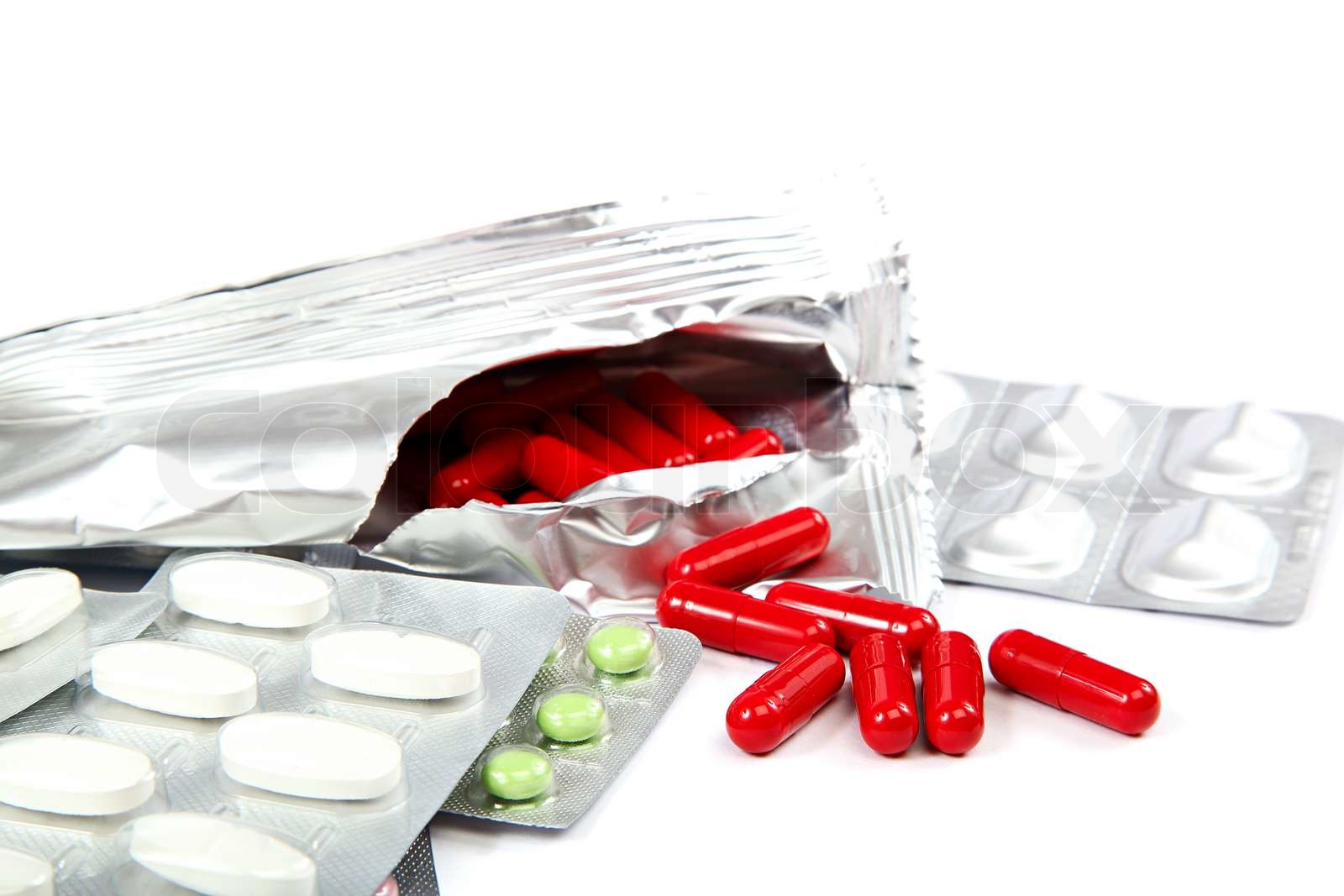 Platte mit Tabletten und Kapseln, die isoliert auf weißem Hintergrund ...