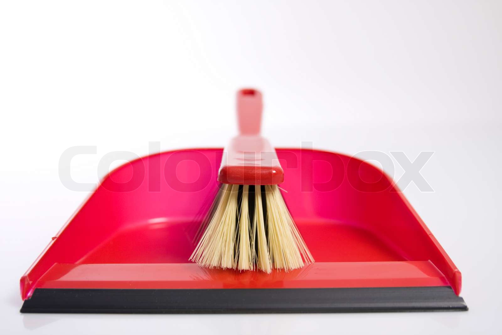 Close up image of a red dustban and a broom | Stock image | Colourbox