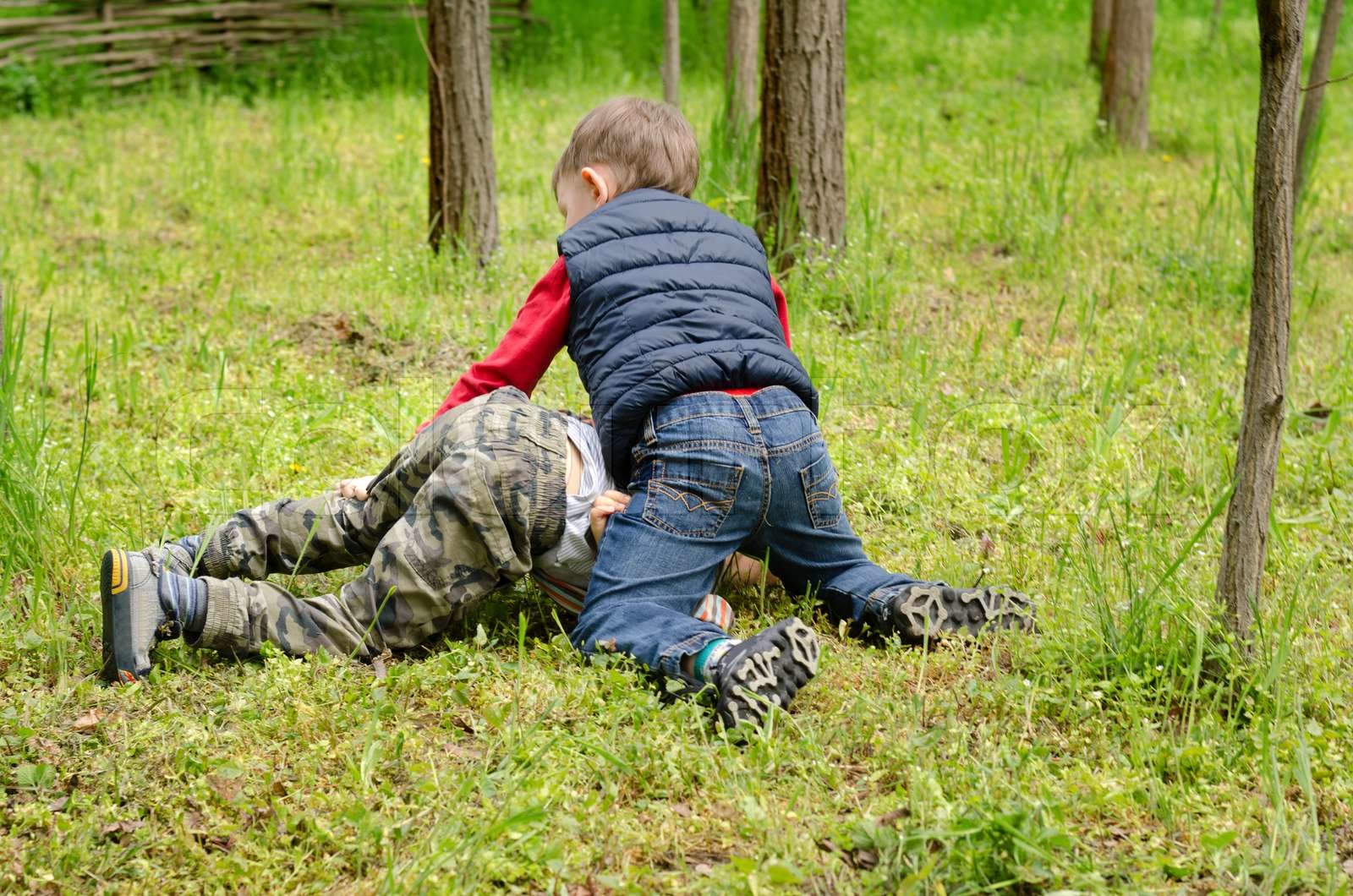 Two young boys fighting on the ground | Stock image | Colourbox