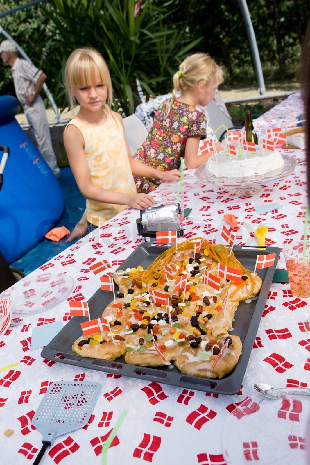 A girl looking at a traditional danish birthday cake decorated with ...