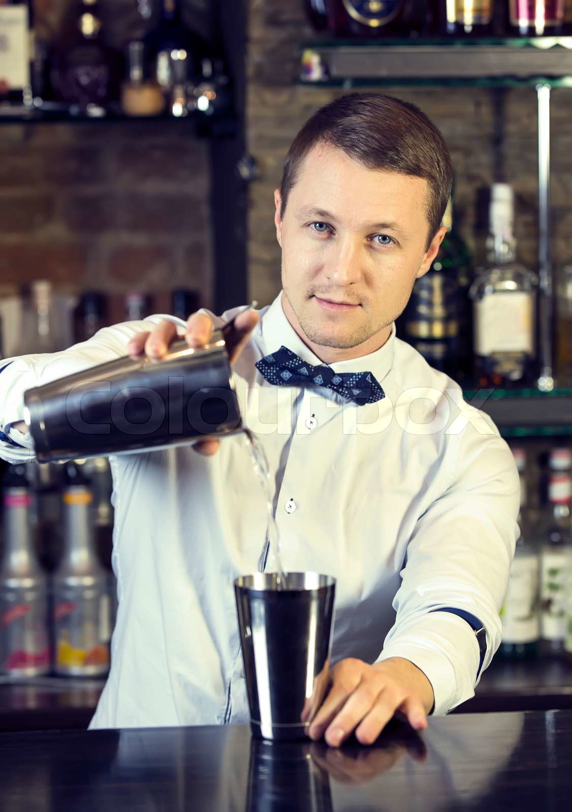young man working as a bartender in a nightclub bar | Stock image ...