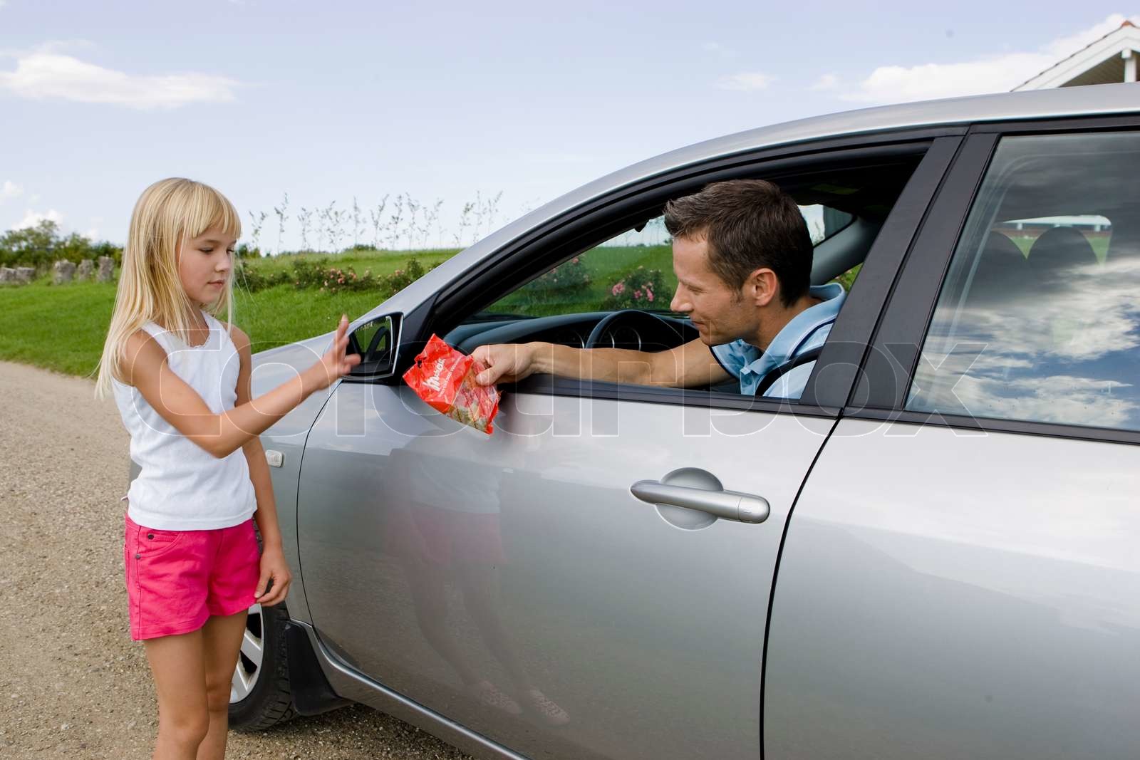 A male stranger in a car trying to lure a girl with candies | Stock ...