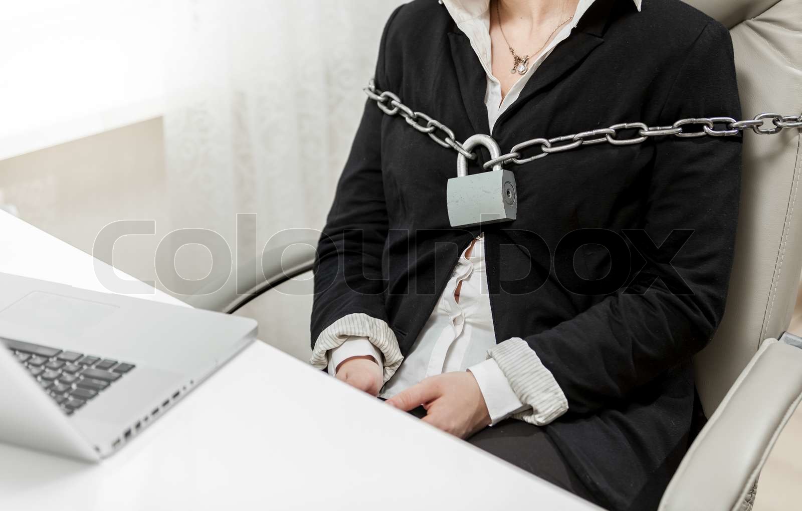 photo of businesswoman tied to chair by metal chain | Stock image ...
