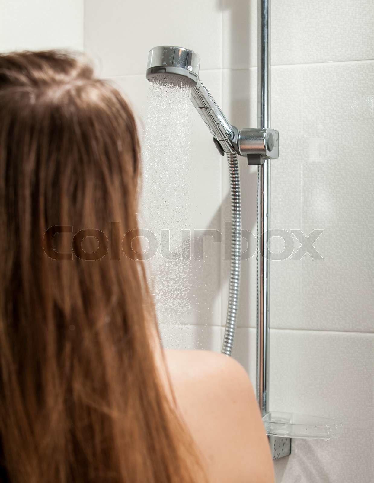 brunette woman washing in shower | Stock image | Colourbox