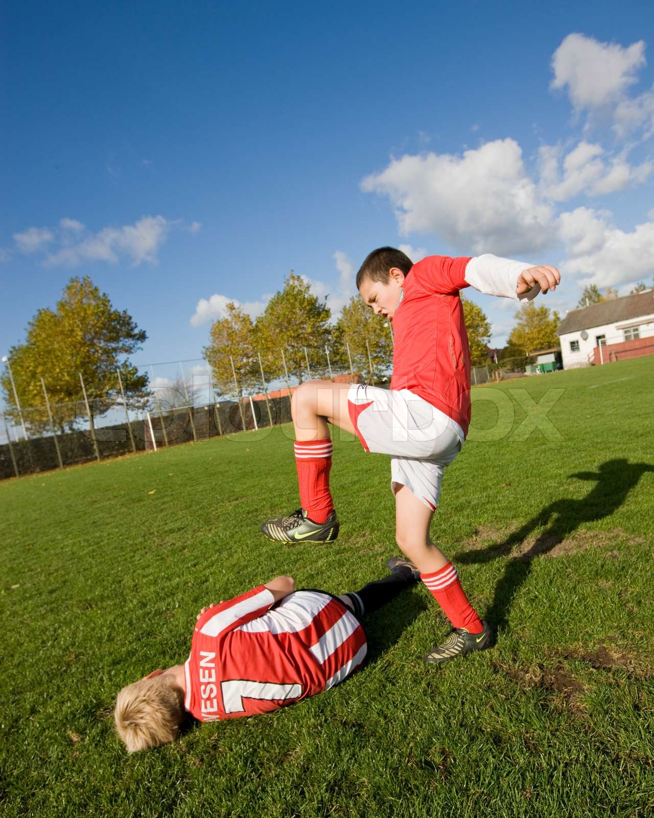 A young agitated football player kicking another player | Stock image ...