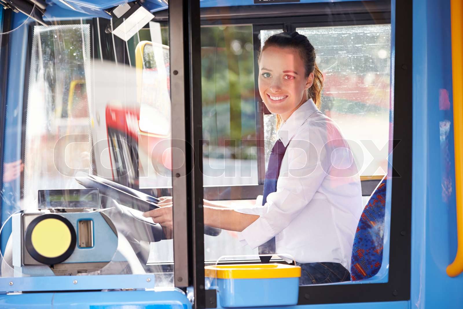 Portrait Of Female Bus Driver Behind Wheel | Stock image | Colourbox