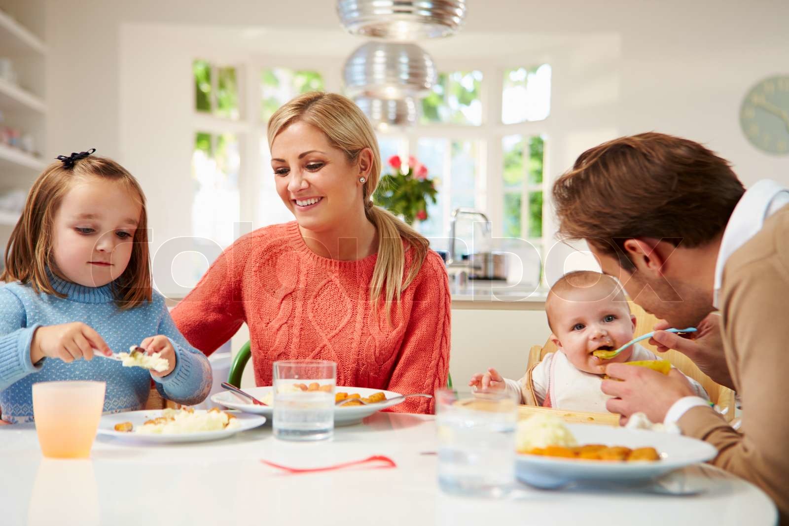 Family With Young Baby Eating Meal At Home | Stock image | Colourbox