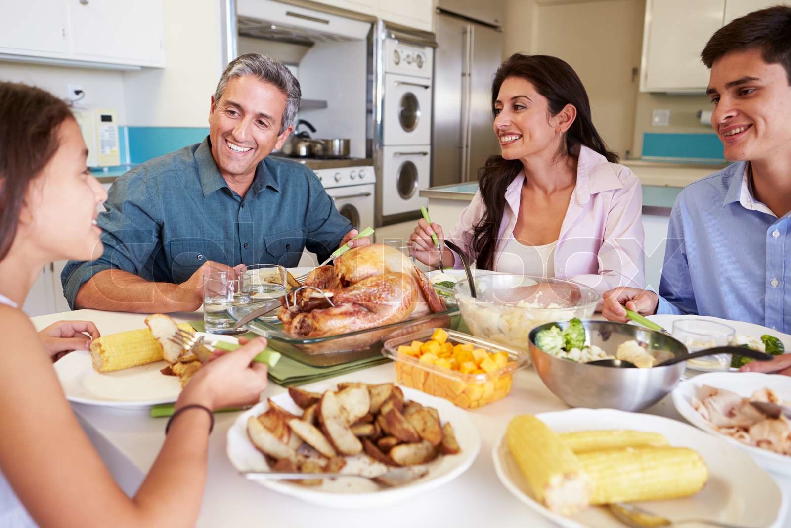 Family Sitting Around Table At Home Eating Meal | Stock image | Colourbox