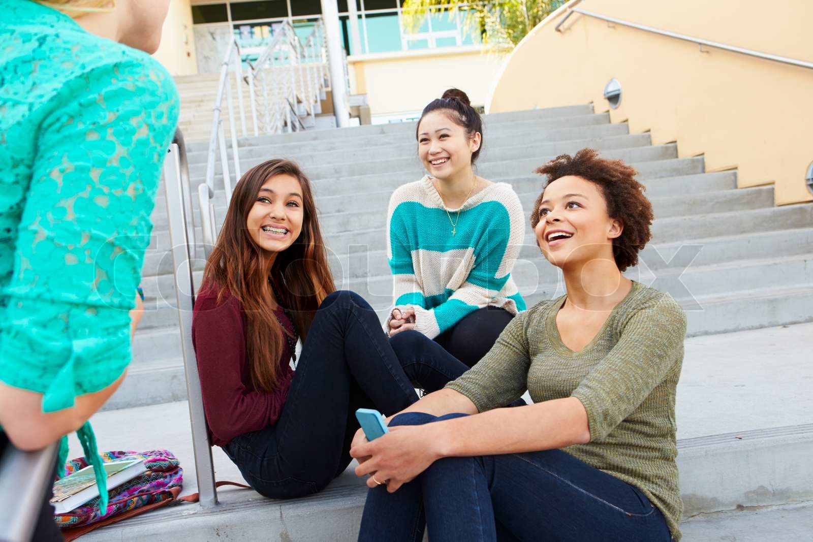 Female High School Students Sitting Outside Building | Stock image ...