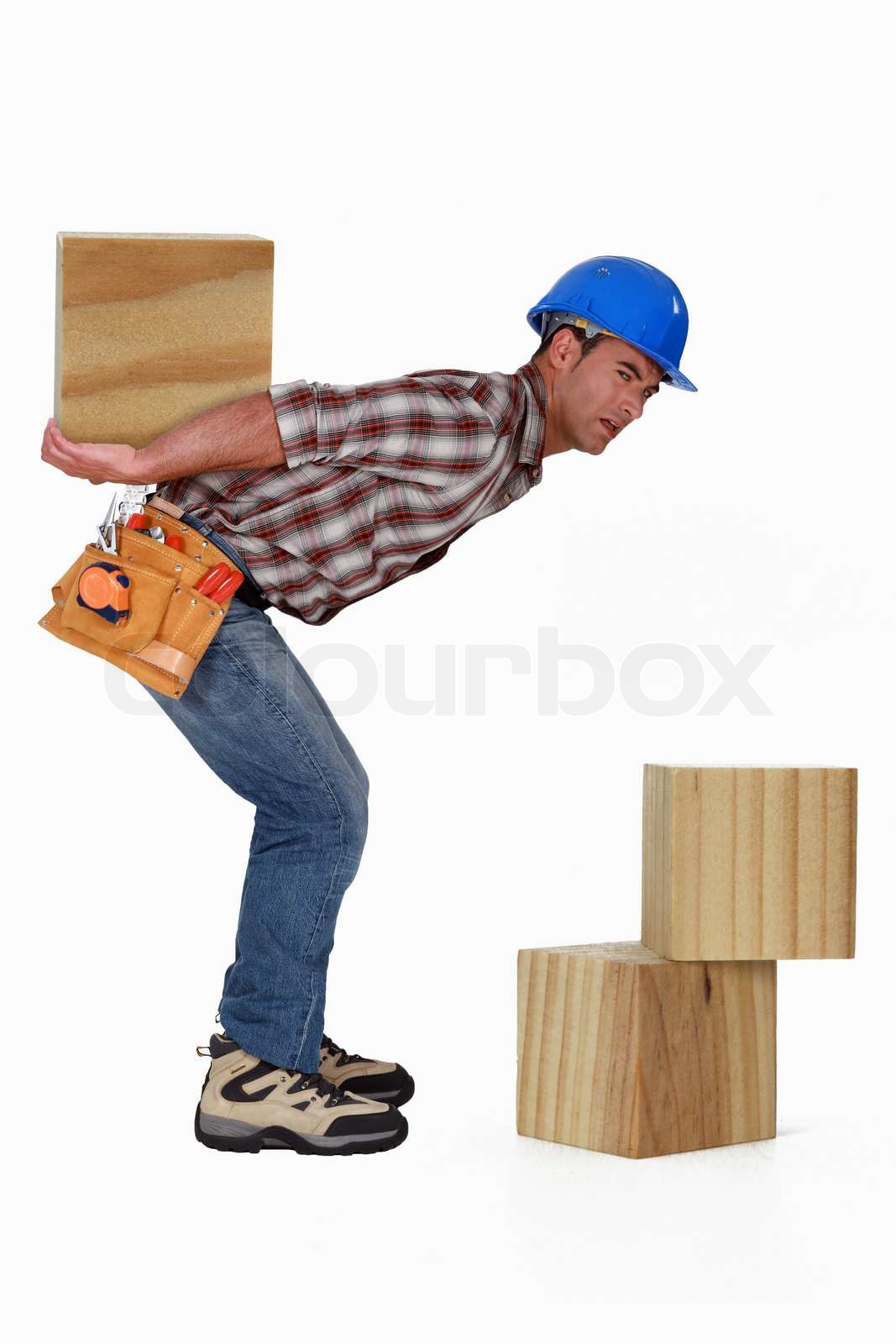 Handyman carrying wooden blocks on his back | Stock image | Colourbox