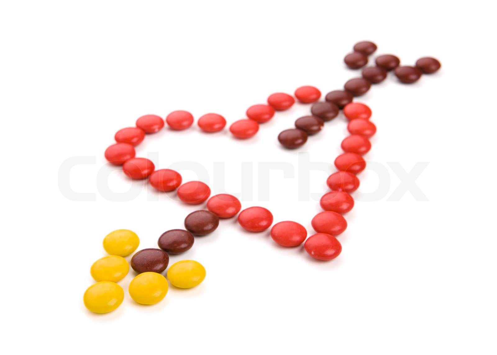 Et hjerte med en pil igennem formet af røde smarties | Stock foto ...