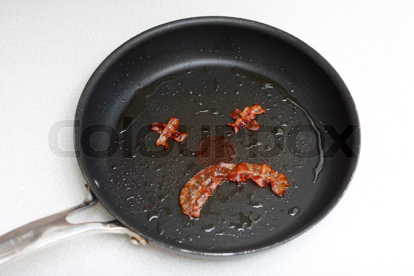 Sad face made from fried bacon | Stock image | Colourbox