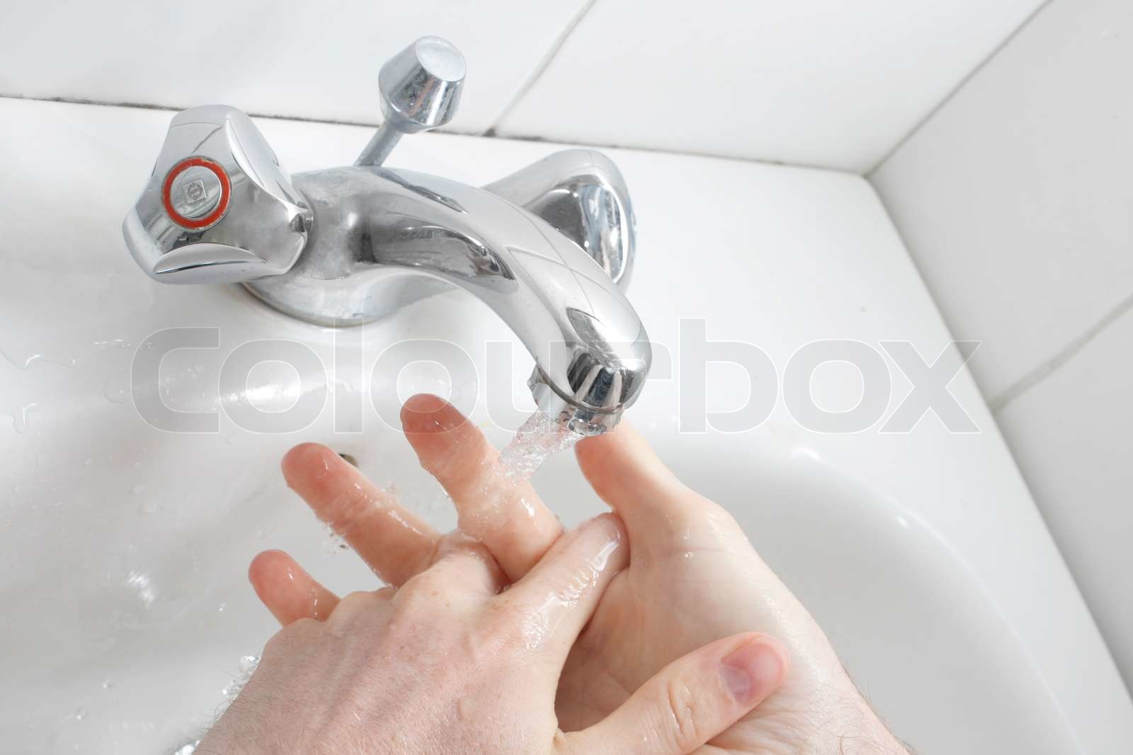 A man washing his hands in the toilet sink | Stock image | Colourbox