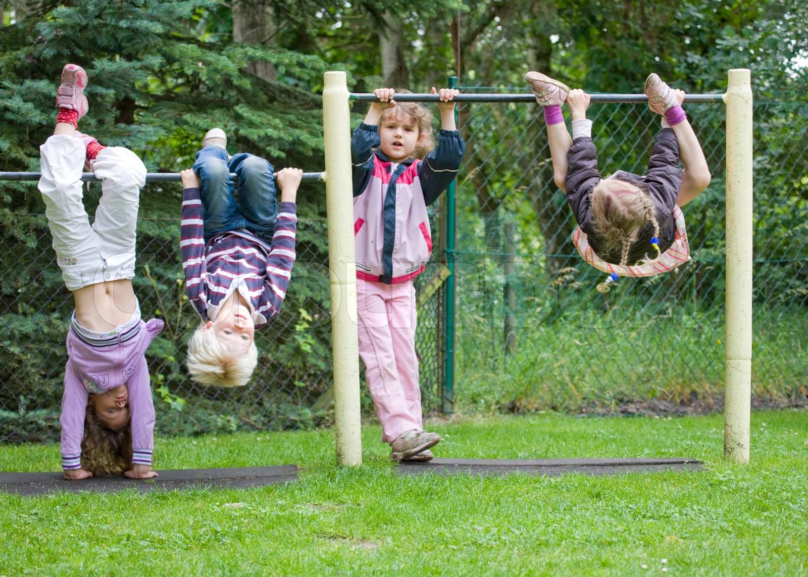 Children in upside down position while playing on a pole | Stock image ...