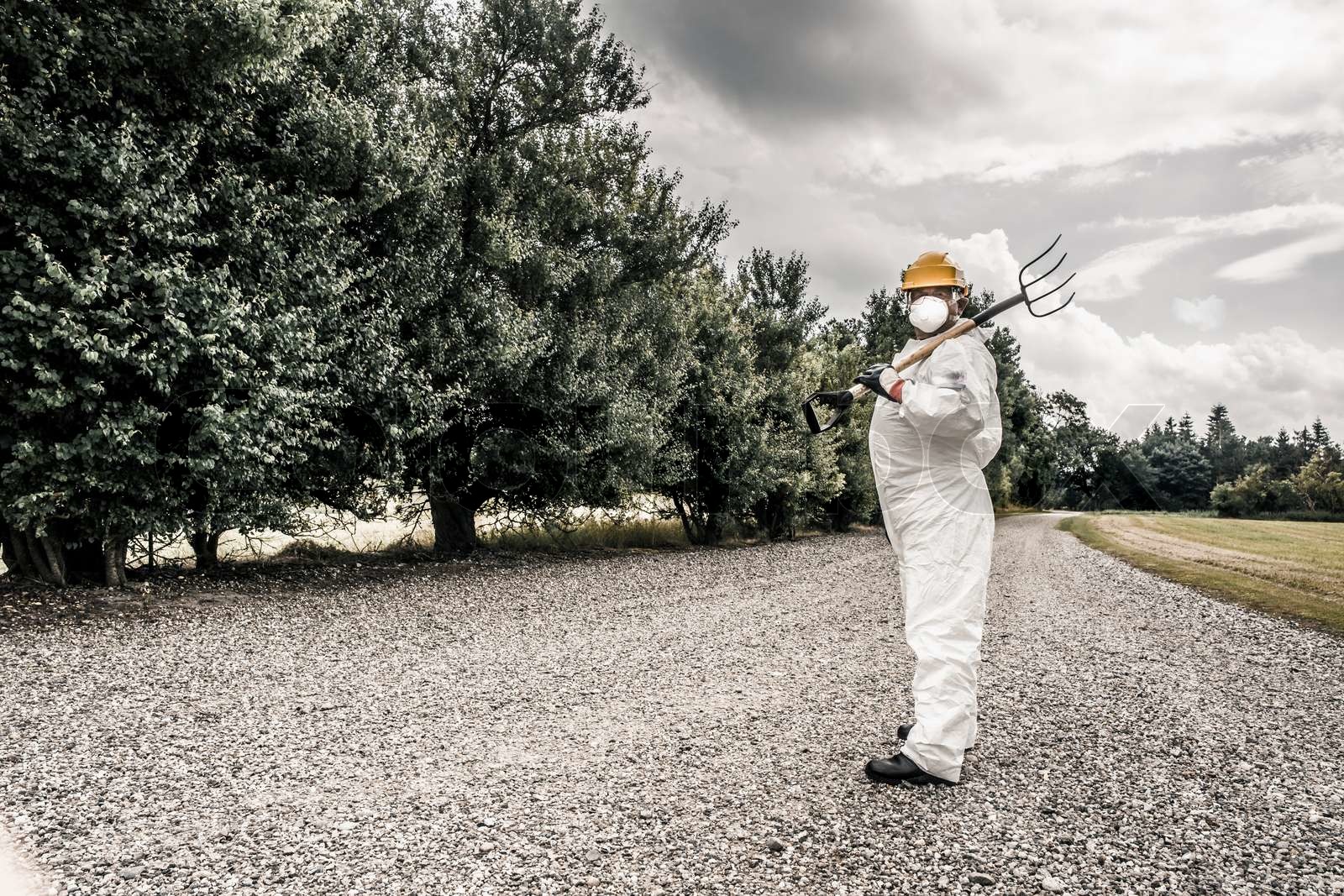 Farmer in secure outfit with a fork | Stock image | Colourbox