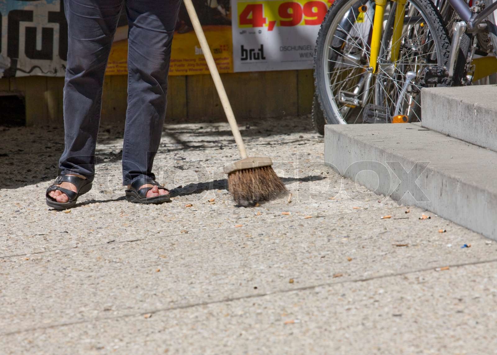 Cropped image of a woman sweeping the street | Stock image | Colourbox