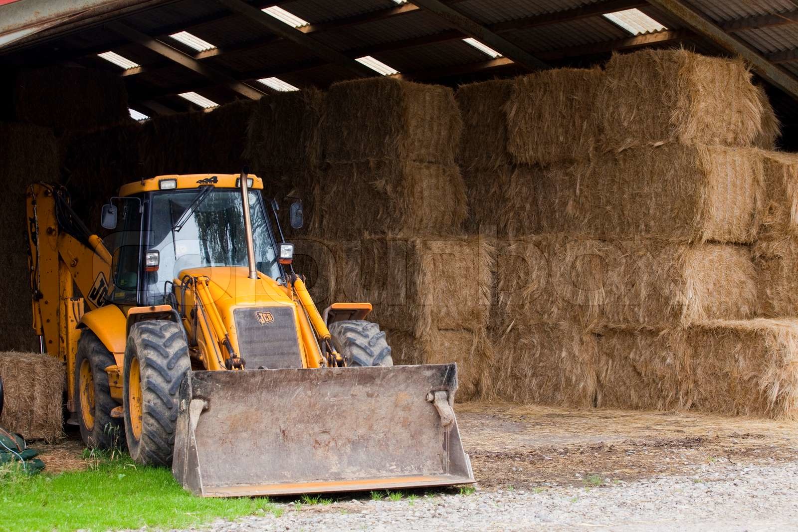 Tractor and hay stack in a barn | Stock image | Colourbox
