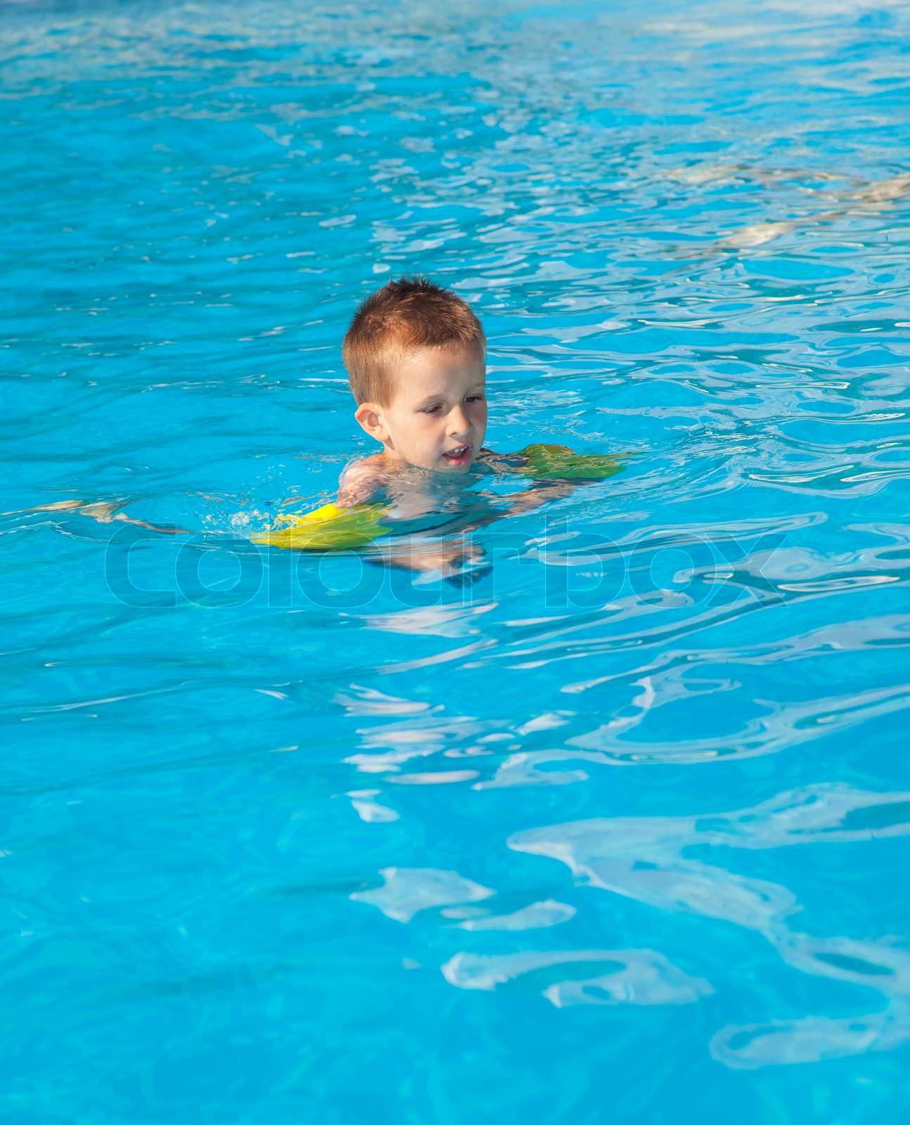 Happy boy swimming with floaties | Stock image | Colourbox