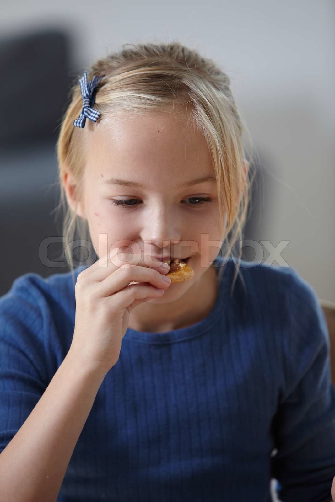 A girl eating a biscuit | Stock image | Colourbox