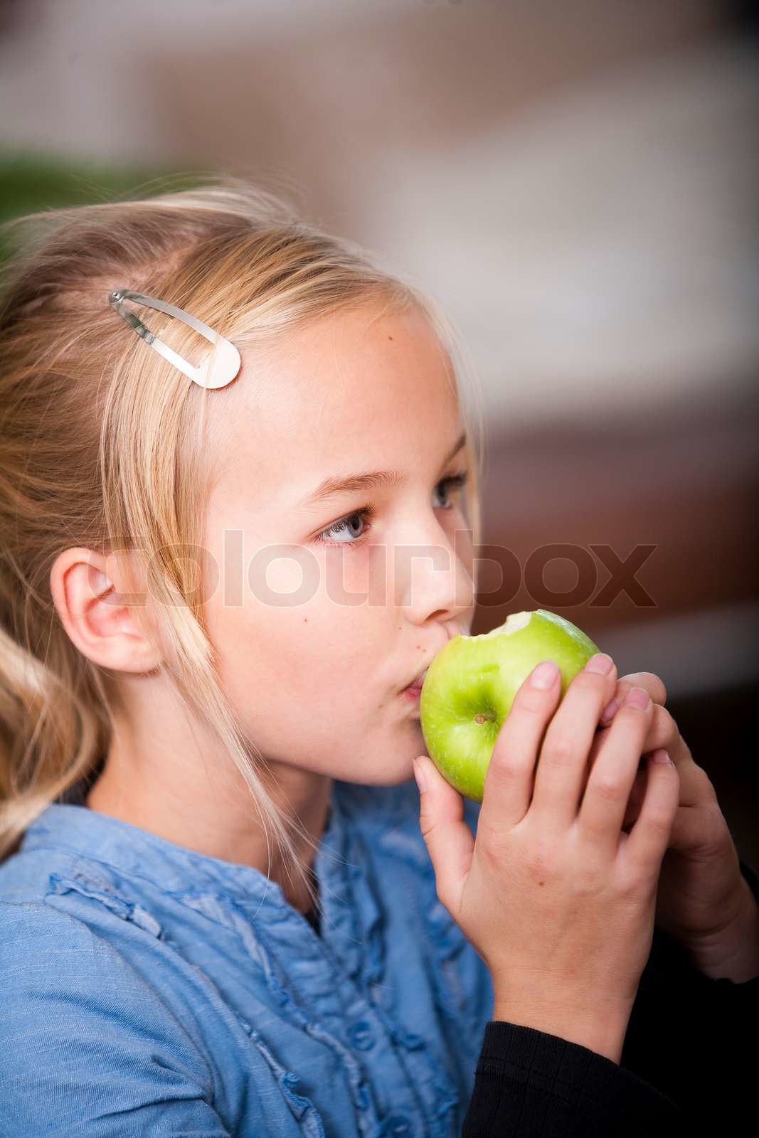A girl eating a green apple | Stock image | Colourbox