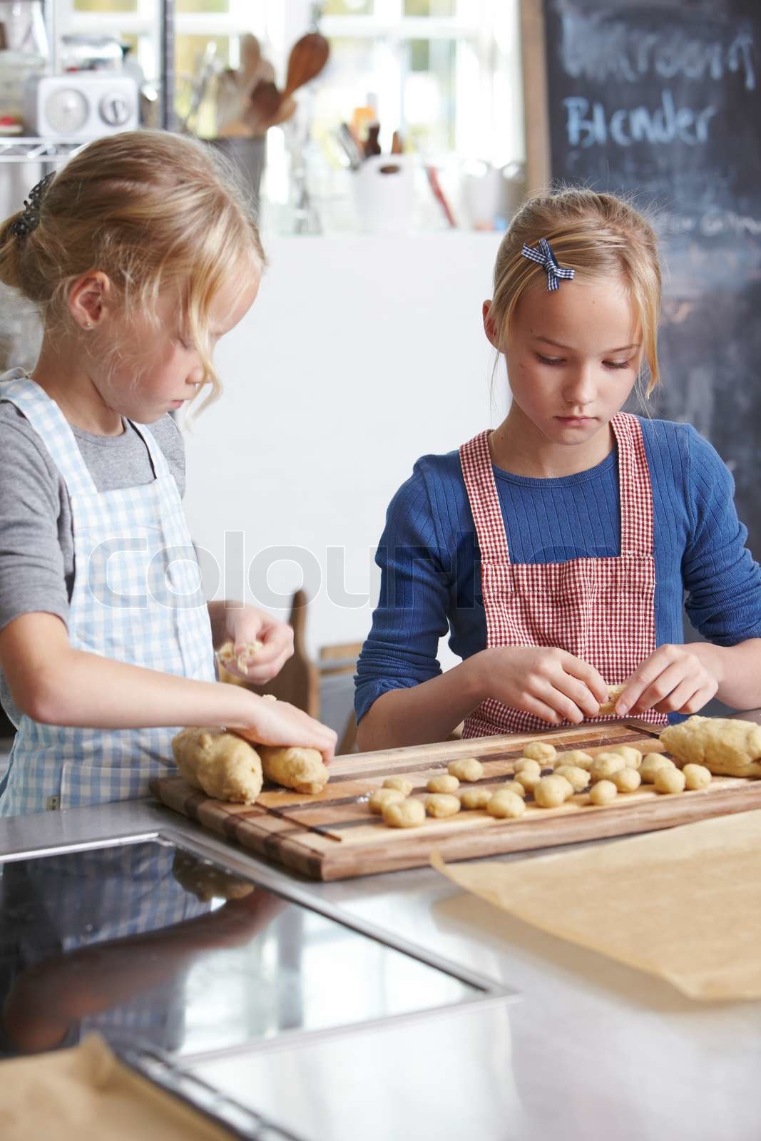 Two girls baking breads and cookies | Stock image | Colourbox