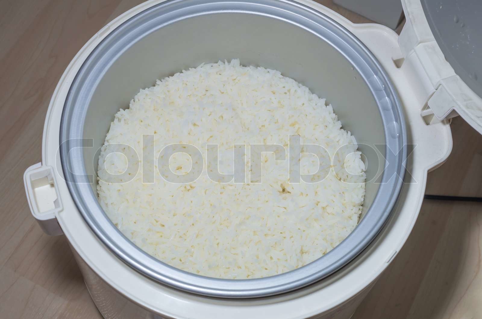 Stream rice in electric rice cooker | Stock image | Colourbox