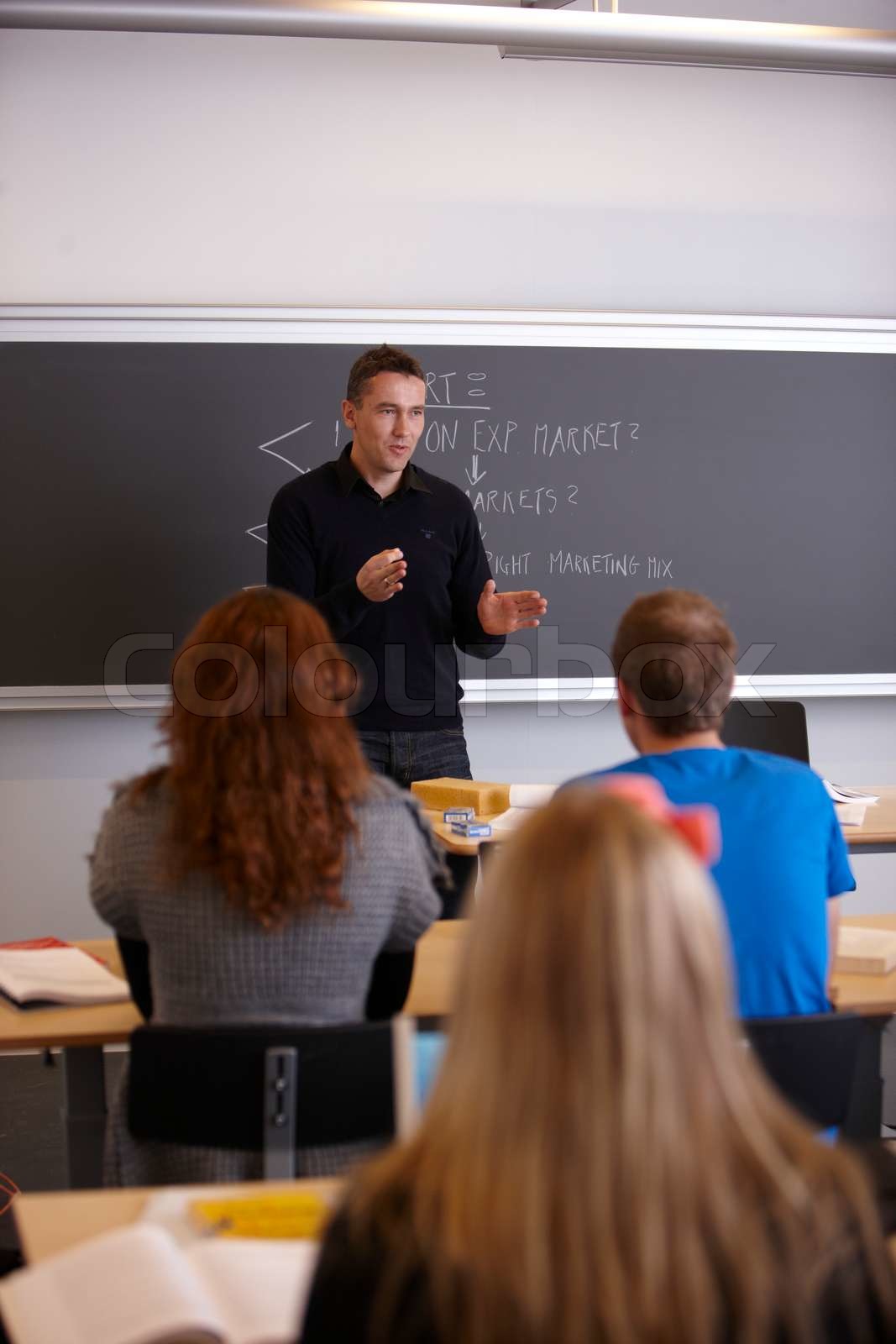 A school professor lecturing his students in a university auditorium ...