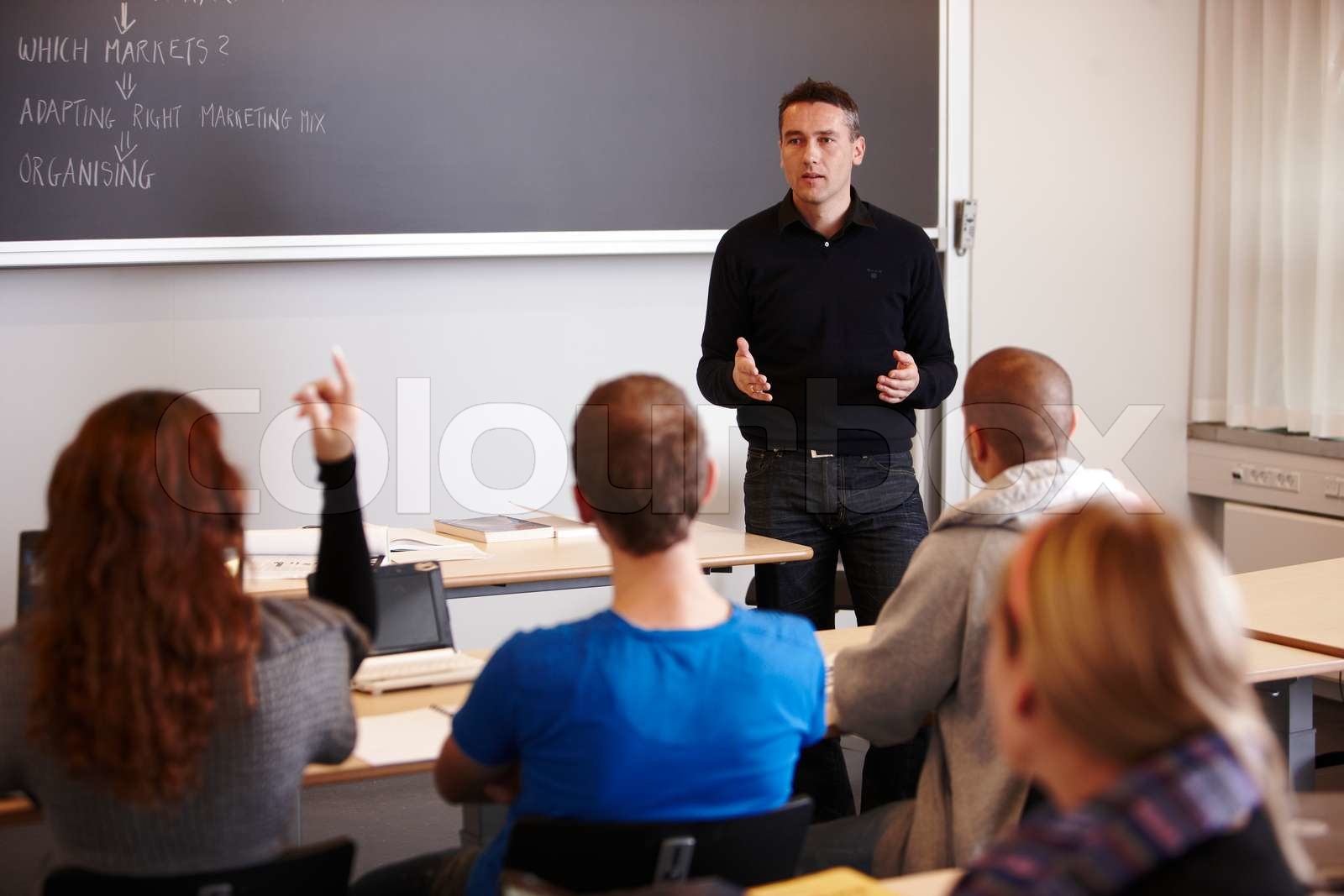 A school professor lecturing his students in a university auditorium ...