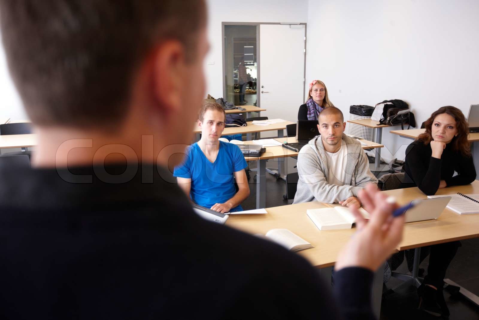 A school professor lecturing his students in a university auditorium ...