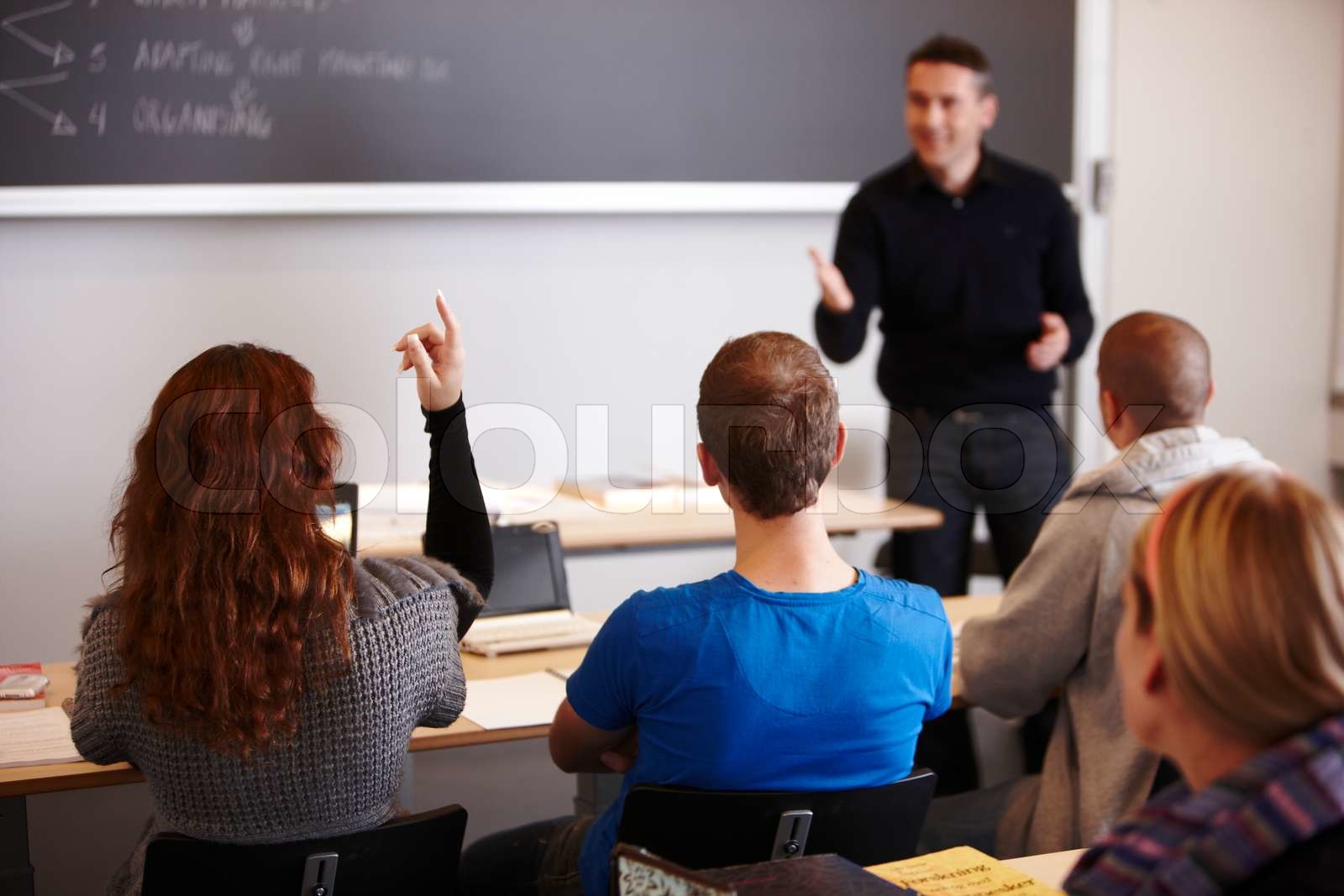 A school professor lecturing his students in a university auditorium ...
