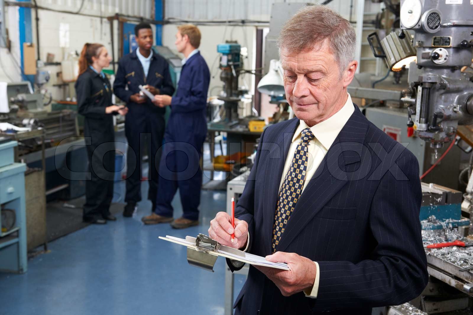 Owner Of Engineering Factory With Staff In Background | Stock image ...