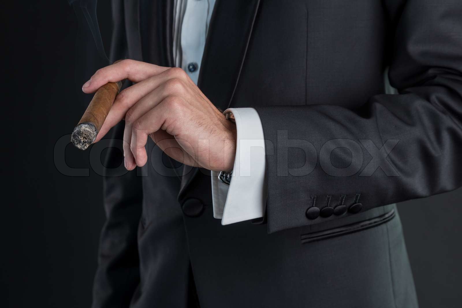 Man in a black suit holding a cigar in a left hand | Stock image ...