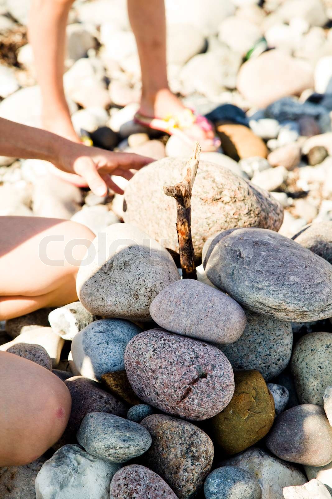 Children playing with stones in the beach | Stock image | Colourbox