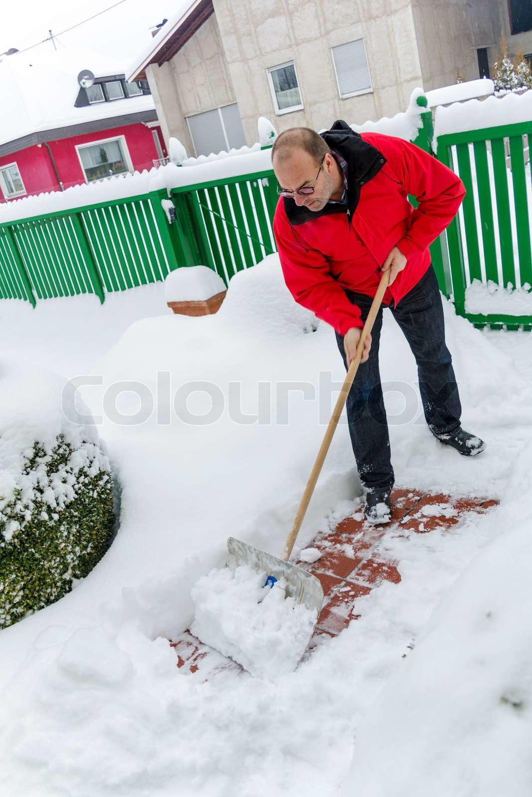 Mann beim Schnee schaufeln | Stock image | Colourbox