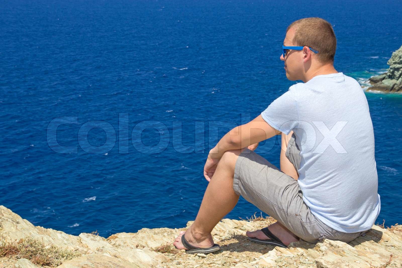 Mann Sitzt Auf Einer Felsigen Klippe Am Meer Stock Bild Colourbox 2054