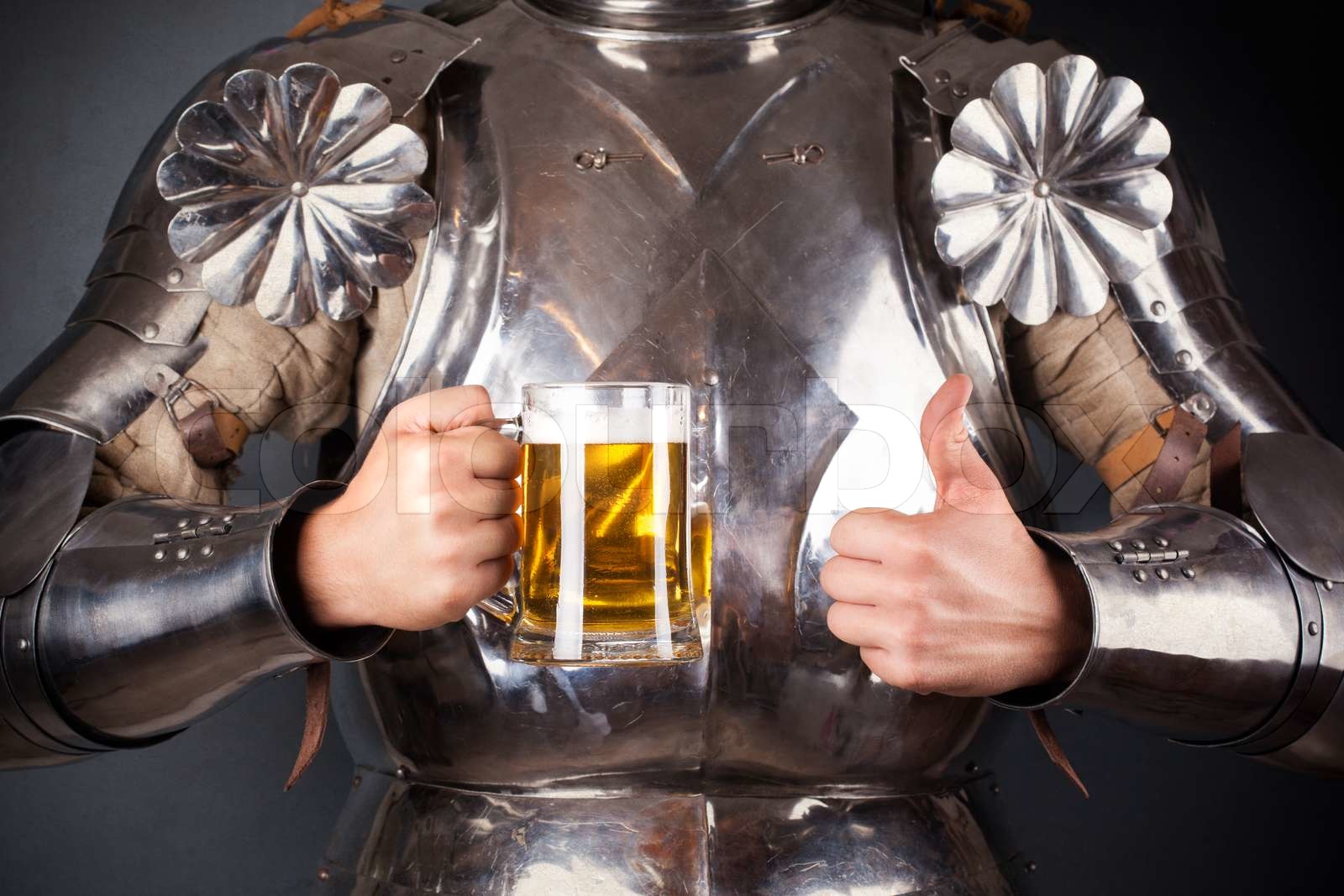 knight wearing armor and holding mug of beer | Stock image | Colourbox