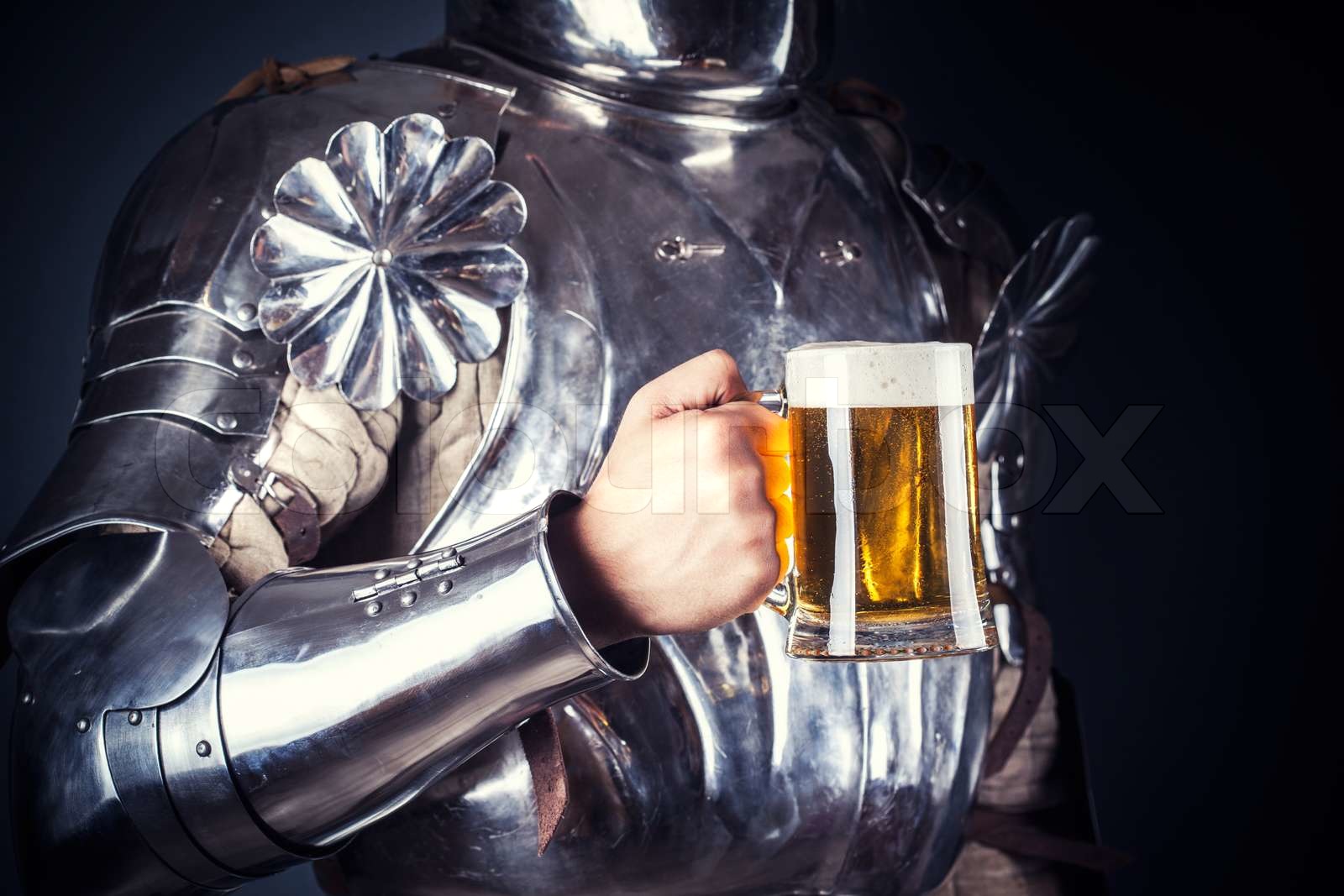 knight wearing armor and holding mug of beer | Stock image | Colourbox