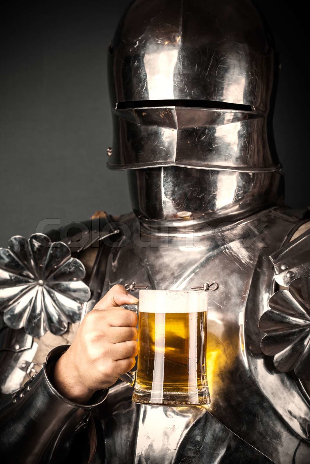 knight wearing armor and holding mug of beer | Stock image | Colourbox