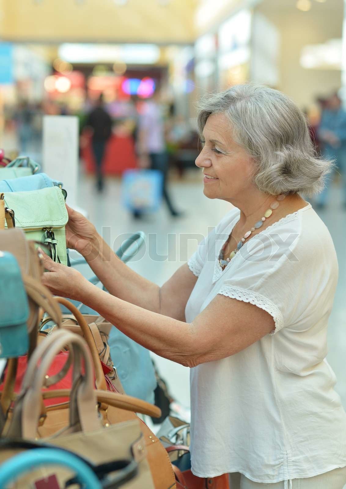 Smiling old lady in store | Stock image | Colourbox