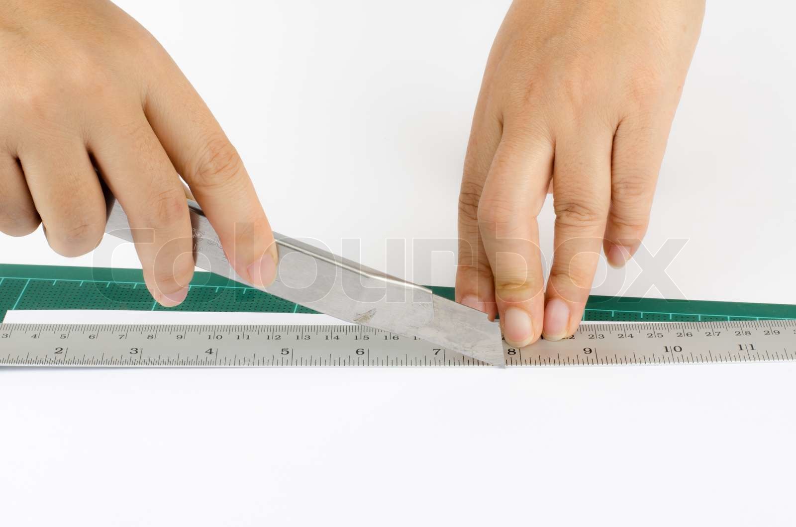 Woman's hand cutting white paper | Stock image | Colourbox