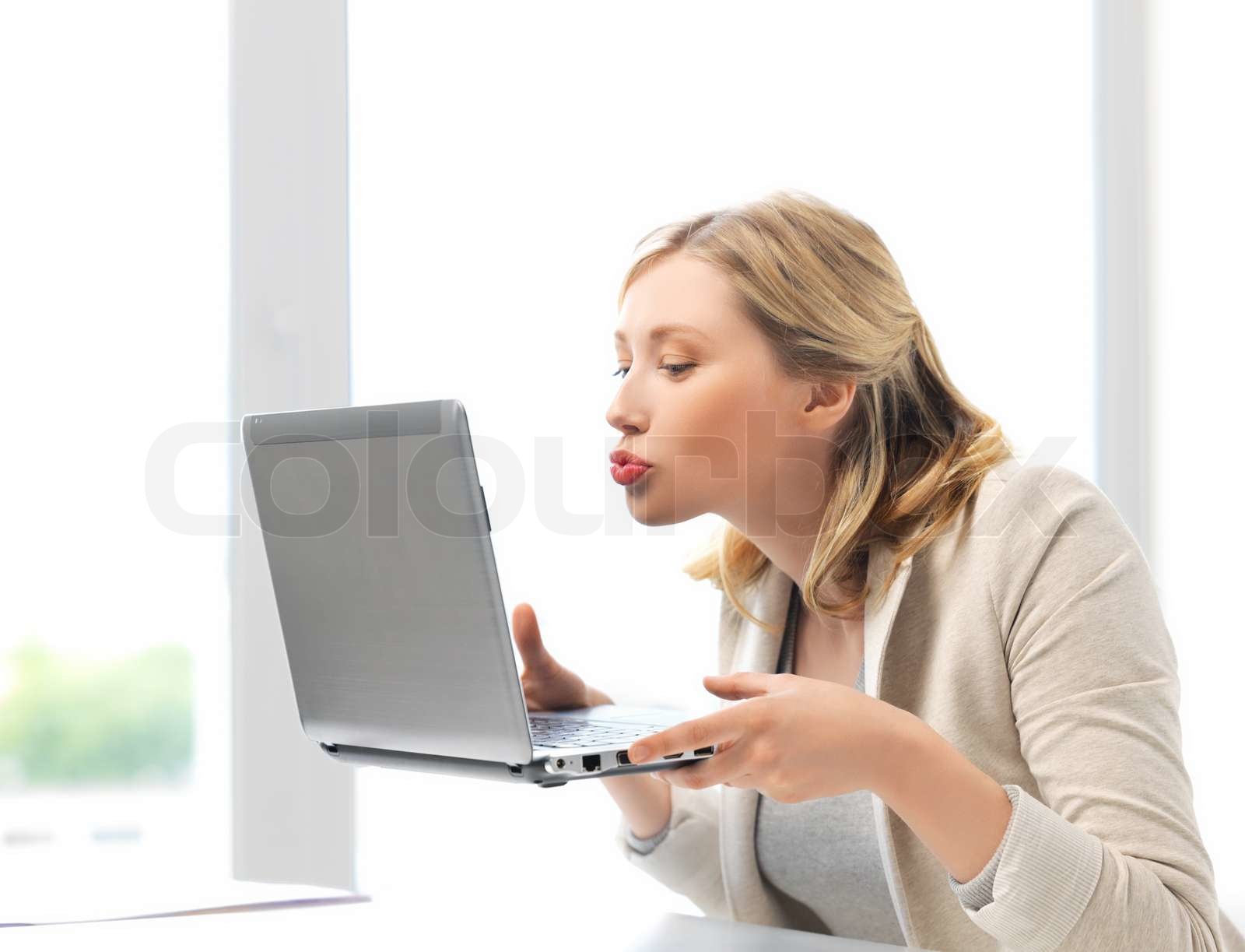 woman sending kisses with laptop computer | Stock image | Colourbox
