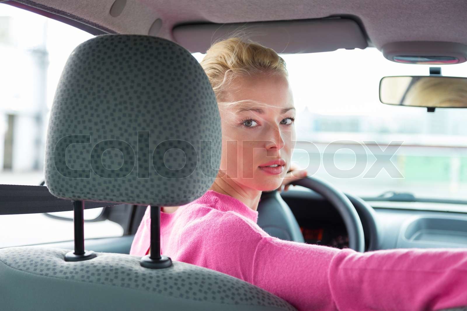 Lady looking back while reversing. | Stock image | Colourbox