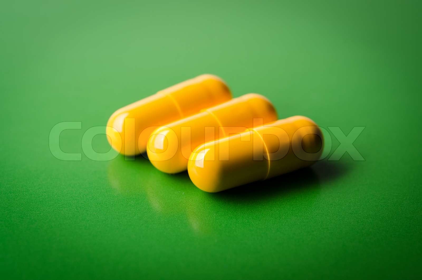 three yellow capsule pill | Stock image | Colourbox