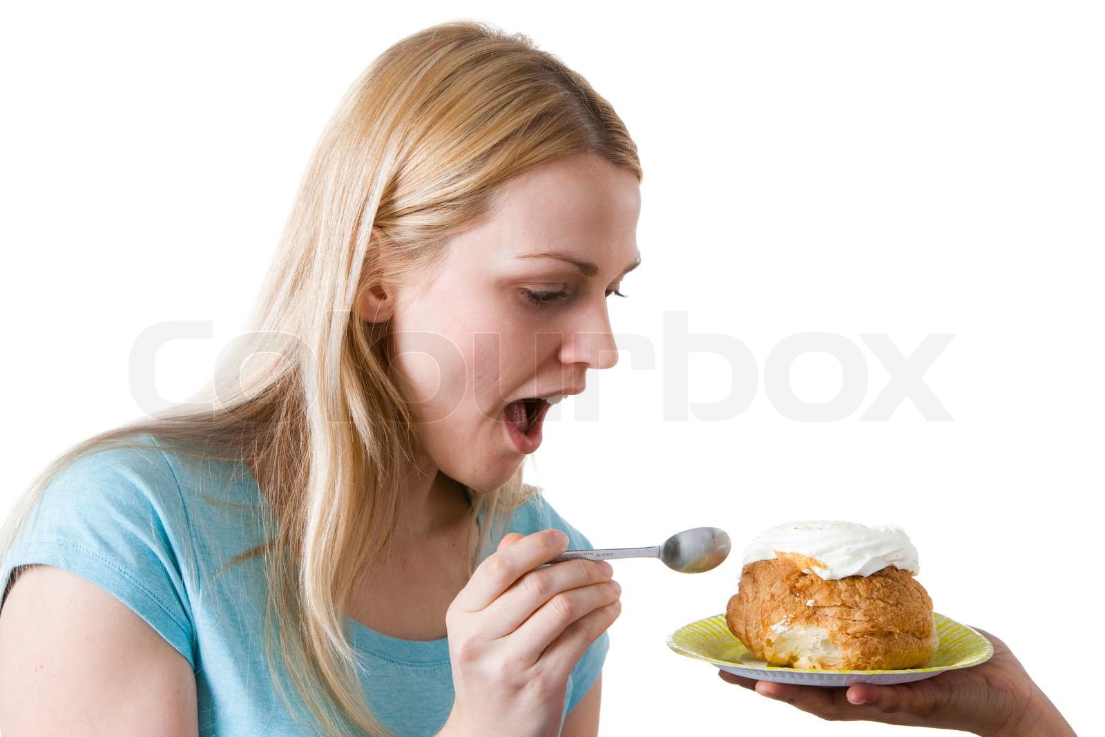 Sulten kvinde der spiser kage med ske | Stock foto | Colourbox