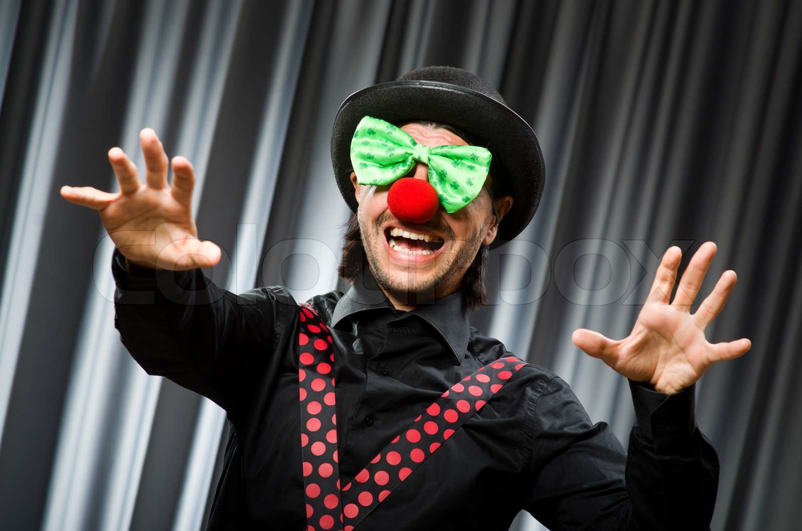 Funny clown in humorous concept against curtain | Stock image | Colourbox