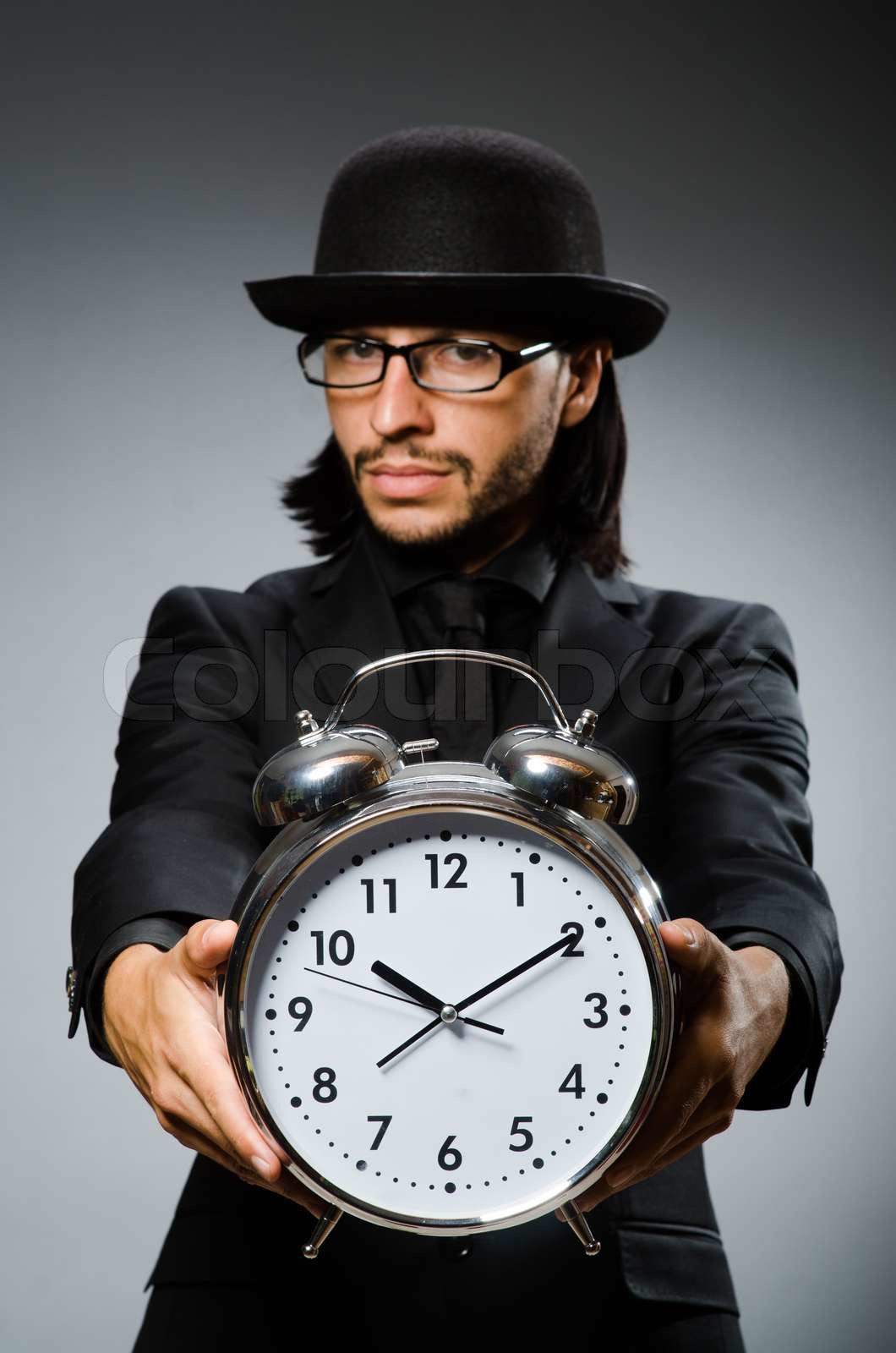 Man with clock wearing vintage hat | Stock image | Colourbox