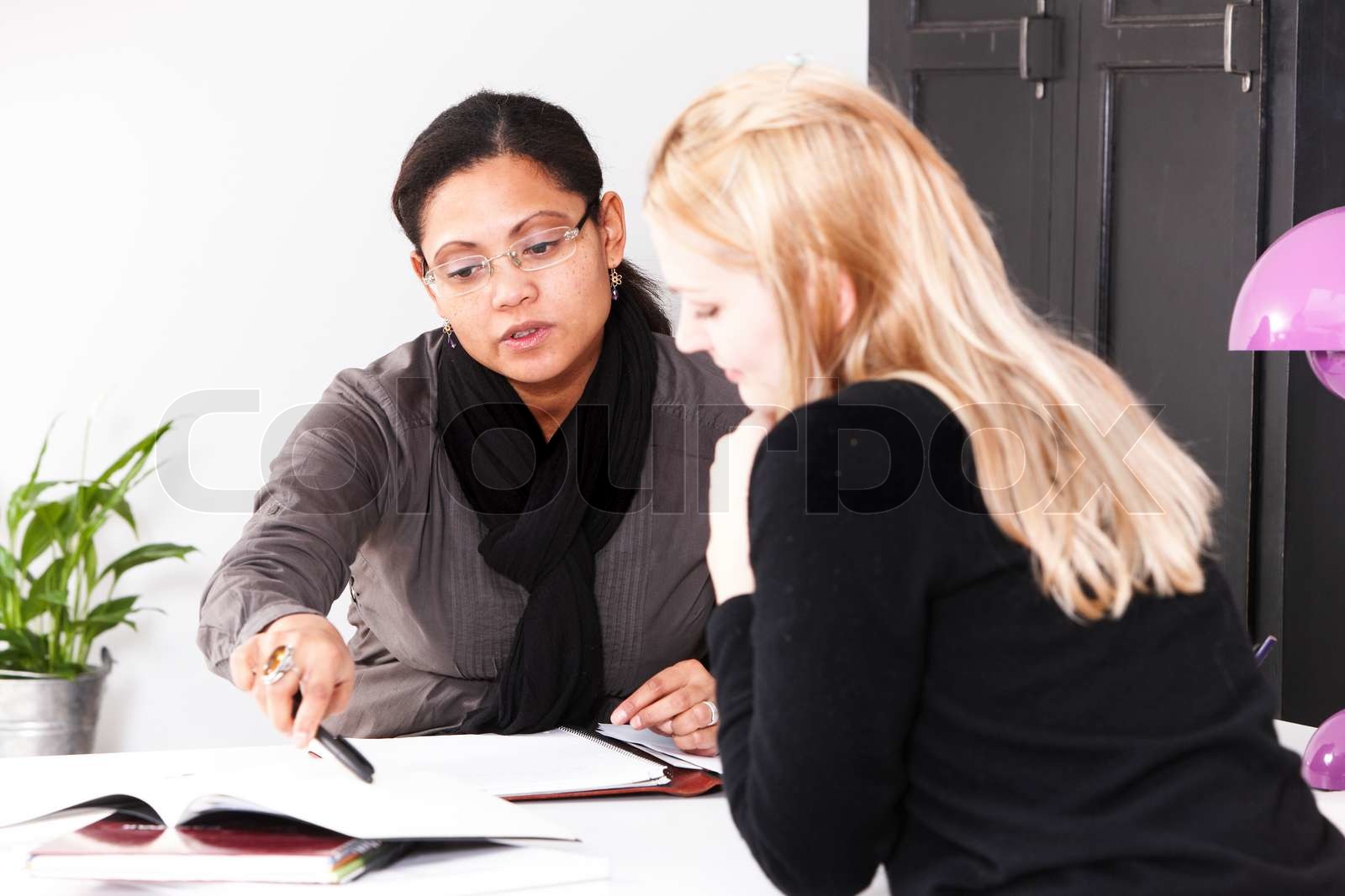 Two female work colleagues brainstorming a project | Stock image ...